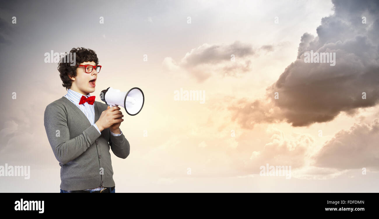 Portrait of young man shouting loudly using megaphone Stock Photo - Alamy