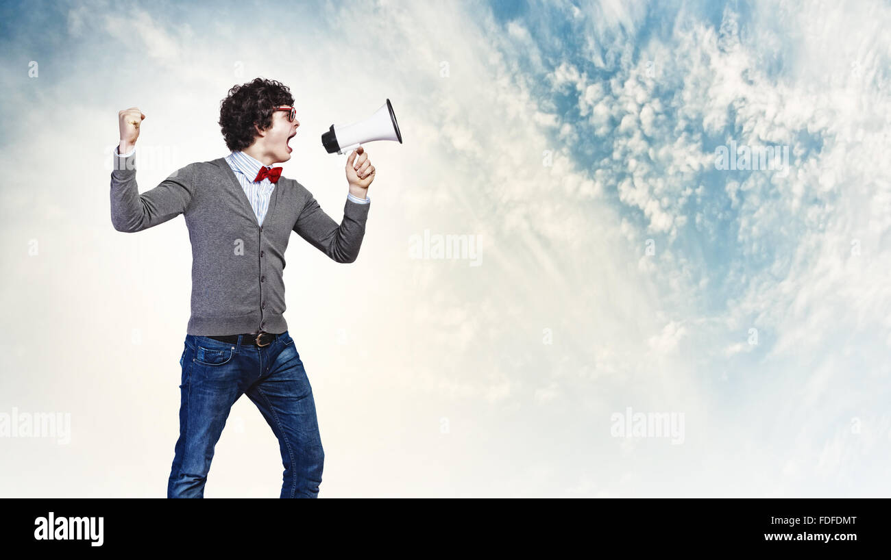 Portrait of young man shouting loudly using megaphone Stock Photo - Alamy