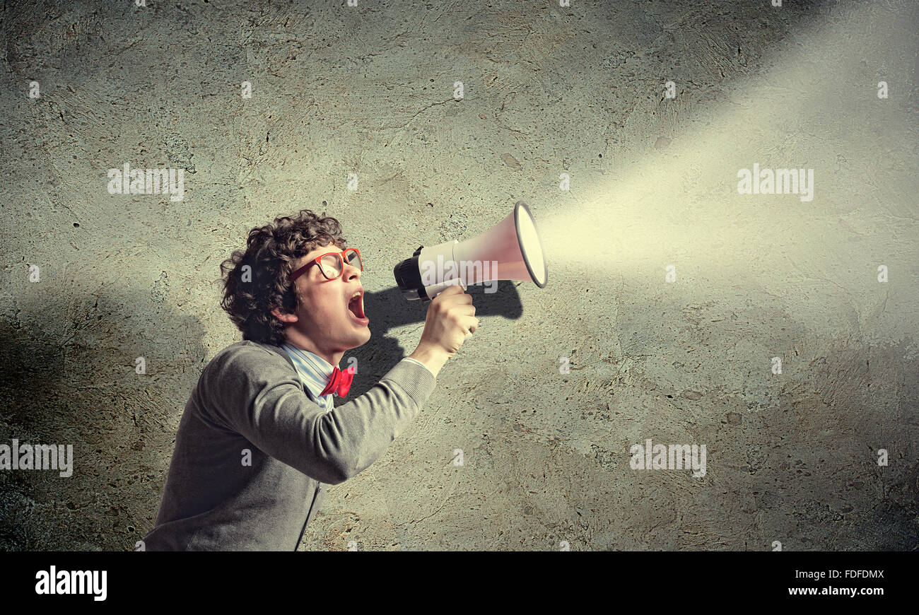 Portrait of young man shouting loudly using megaphone Stock Photo - Alamy