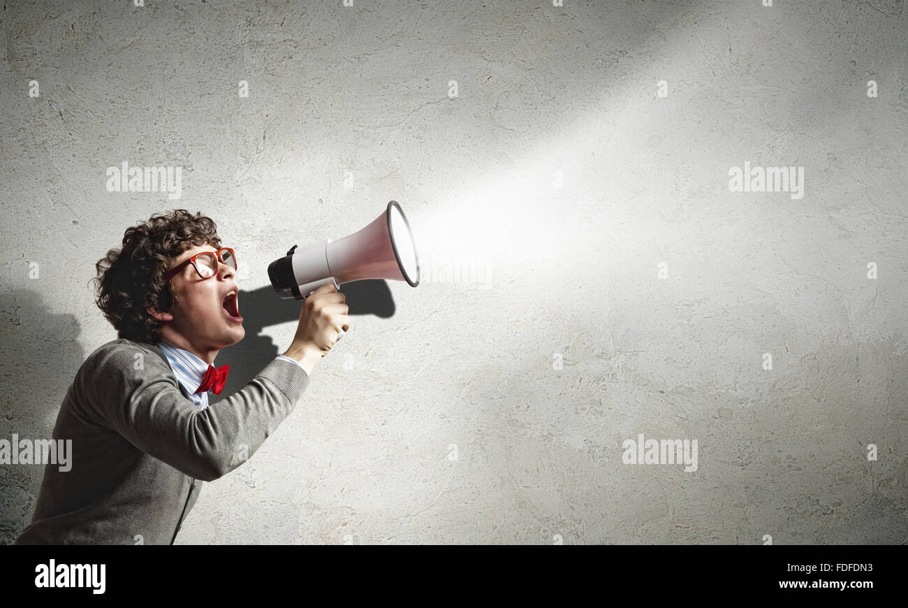 Portrait of young man shouting loudly using megaphone Stock Photo - Alamy