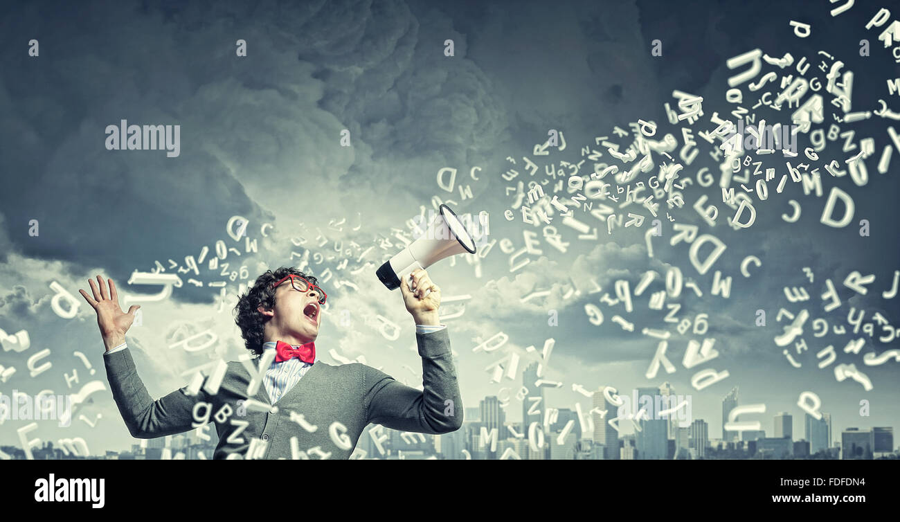 Portrait of young man shouting loudly using megaphone Stock Photo - Alamy