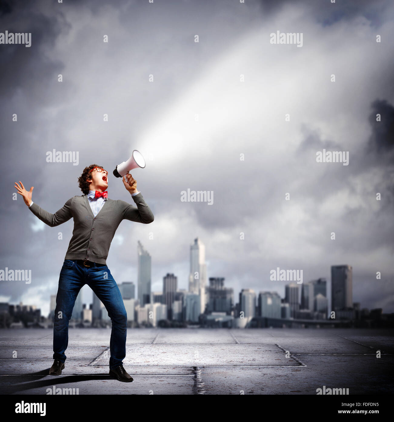 Portrait of young man shouting loudly using megaphone Stock Photo - Alamy