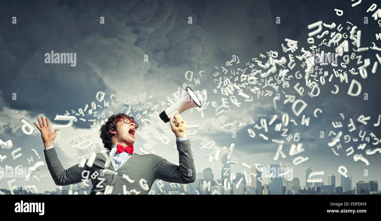 Portrait of young man shouting loudly using megaphone Stock Photo - Alamy