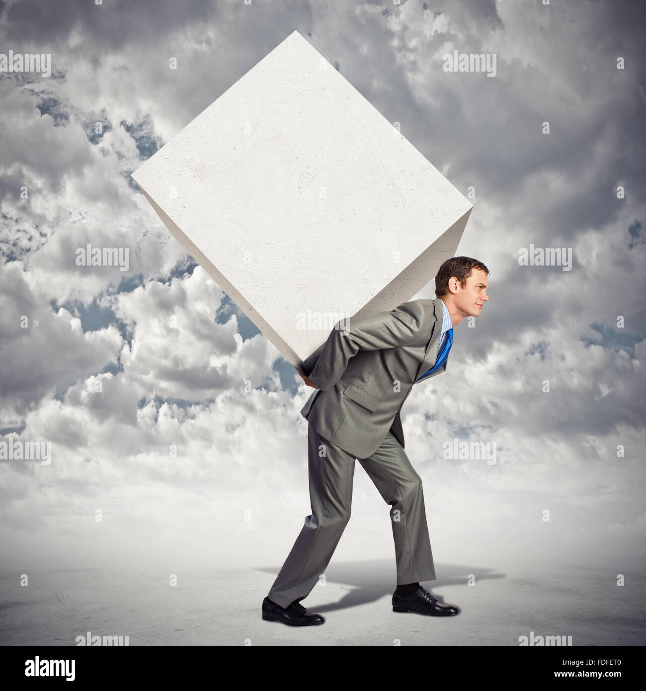 Image of businessman carrying big white cube on his back Stock Photo ...