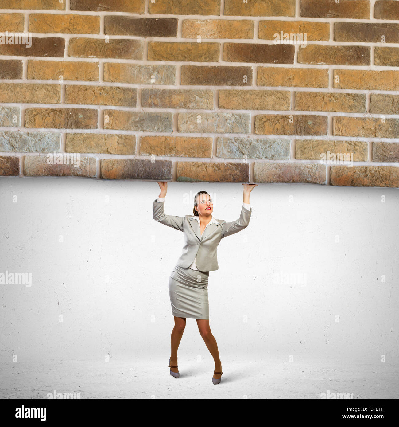 Image of businesswoman lifting brick wall above head Stock Photo - Alamy