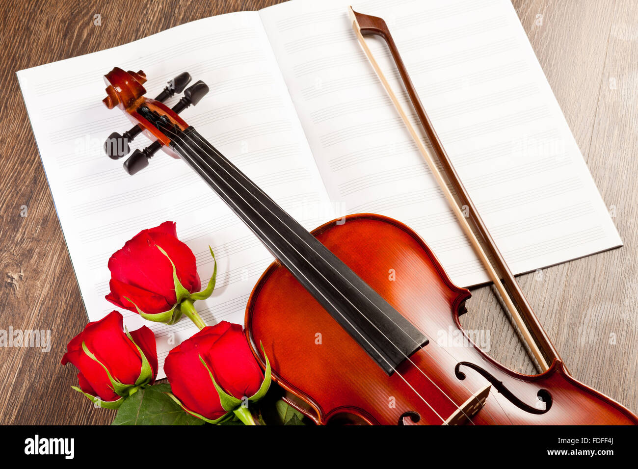 Red roses and a violin on the table Stock Photo - Alamy
