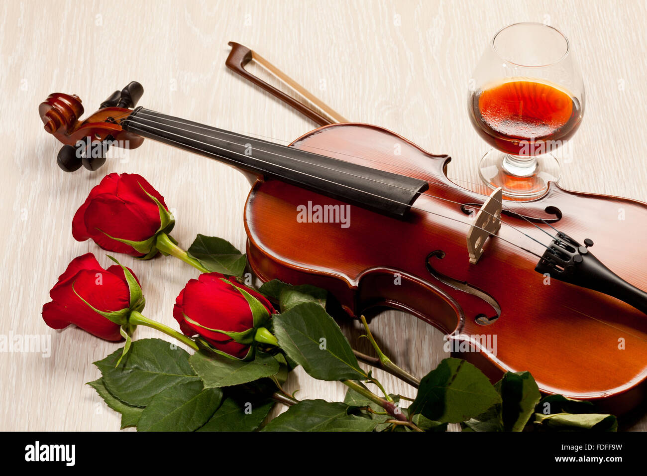Red roses and a violin on the table Stock Photo - Alamy