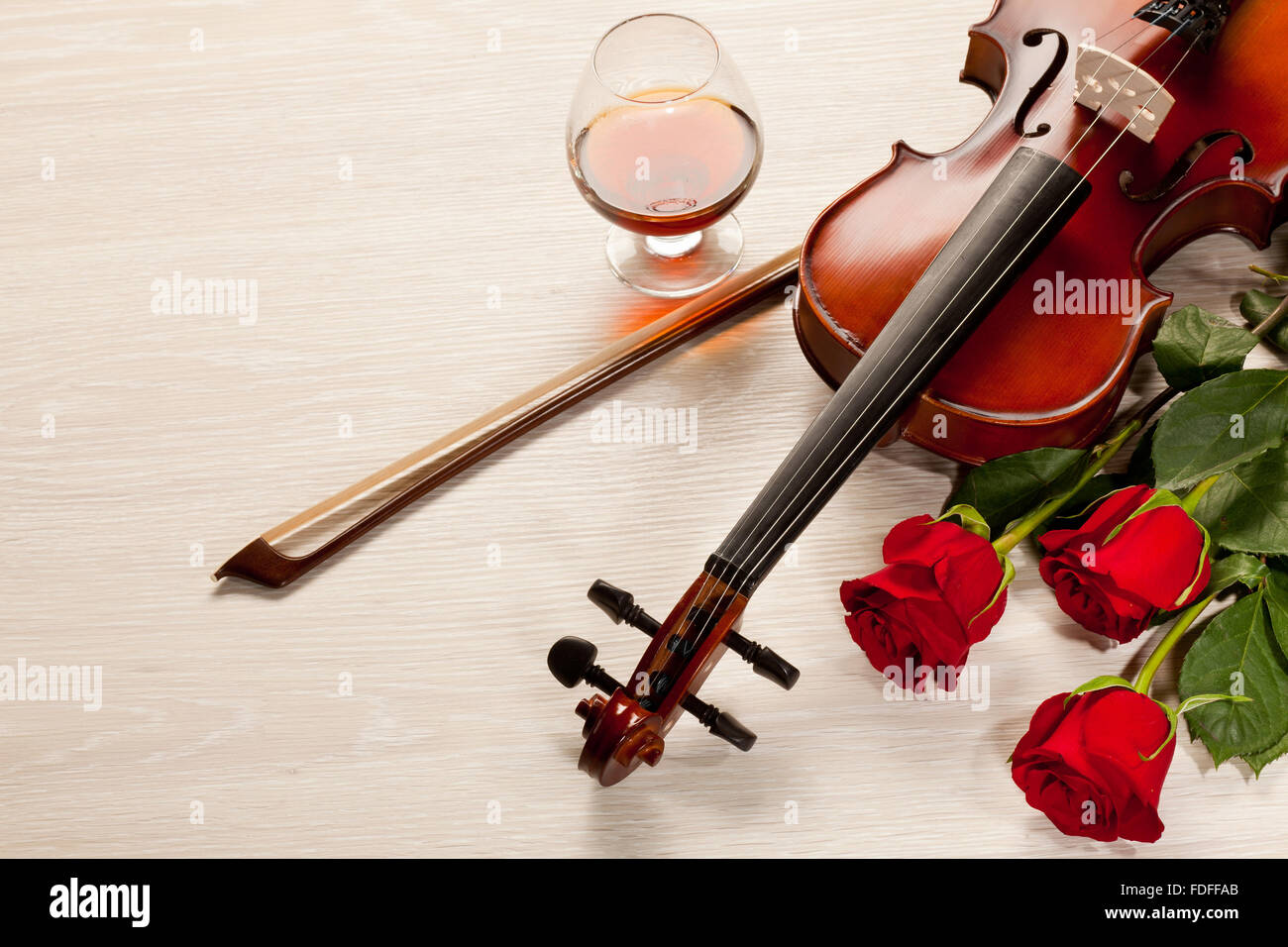 Red roses and a violin on the table Stock Photo - Alamy