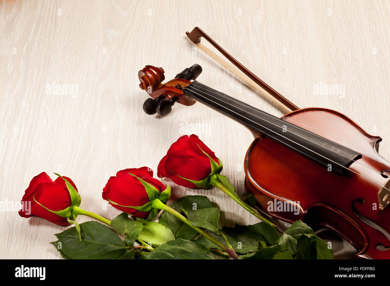 Red roses and a violin on the table Stock Photo - Alamy