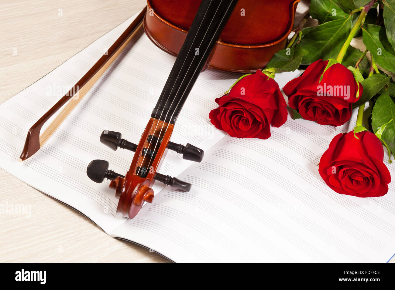 Red roses and a violin on the table Stock Photo - Alamy