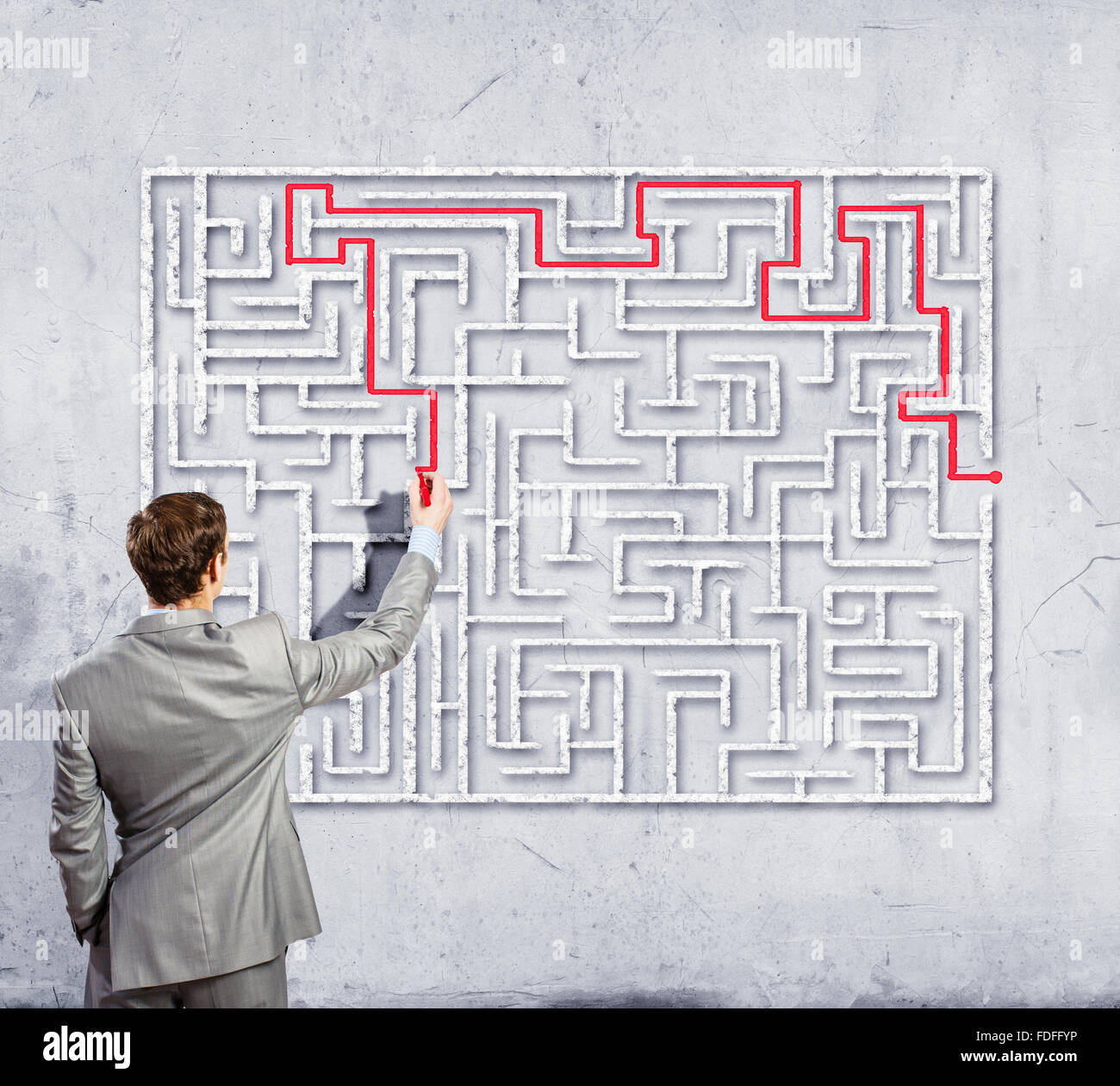Back view image of young businessman trying to find way out of maze ...
