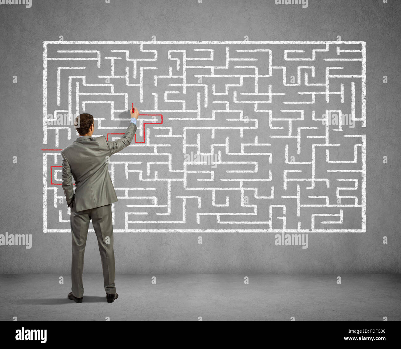 Back view image of young businessman trying to find way out of maze ...