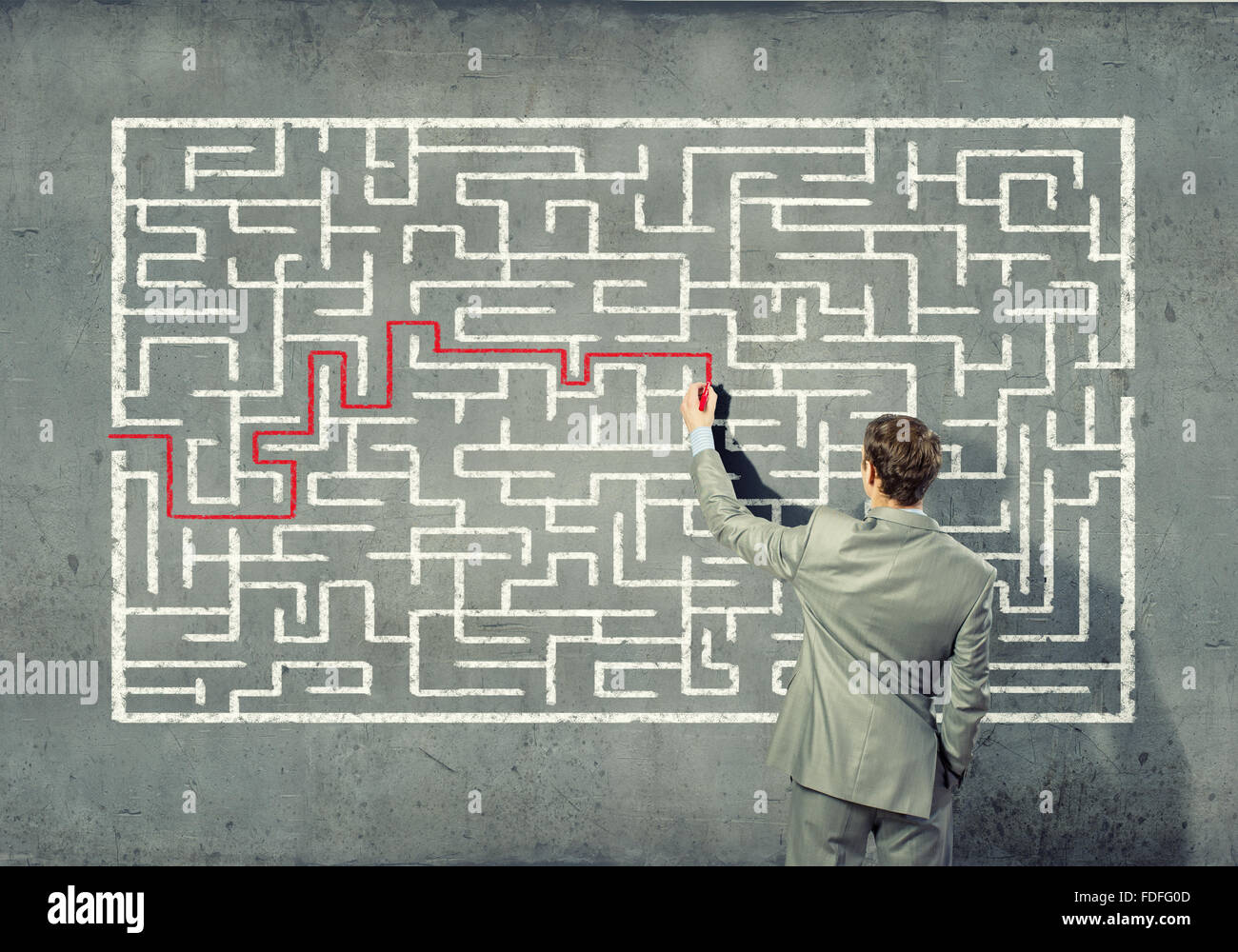 Back view image of young businessman trying to find way out of maze ...