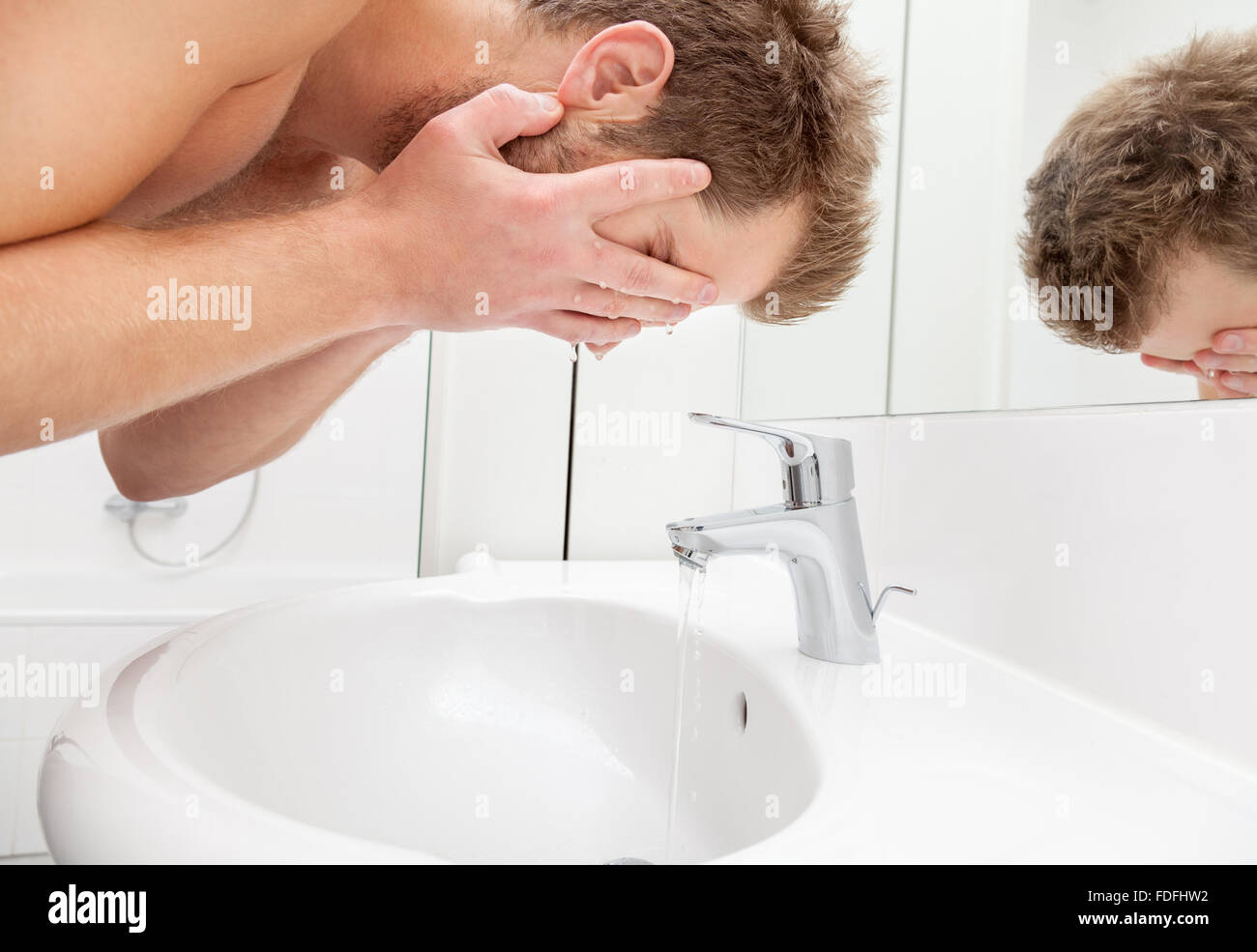 Man washing his face in the bathroom sink Stock Photo - Alamy