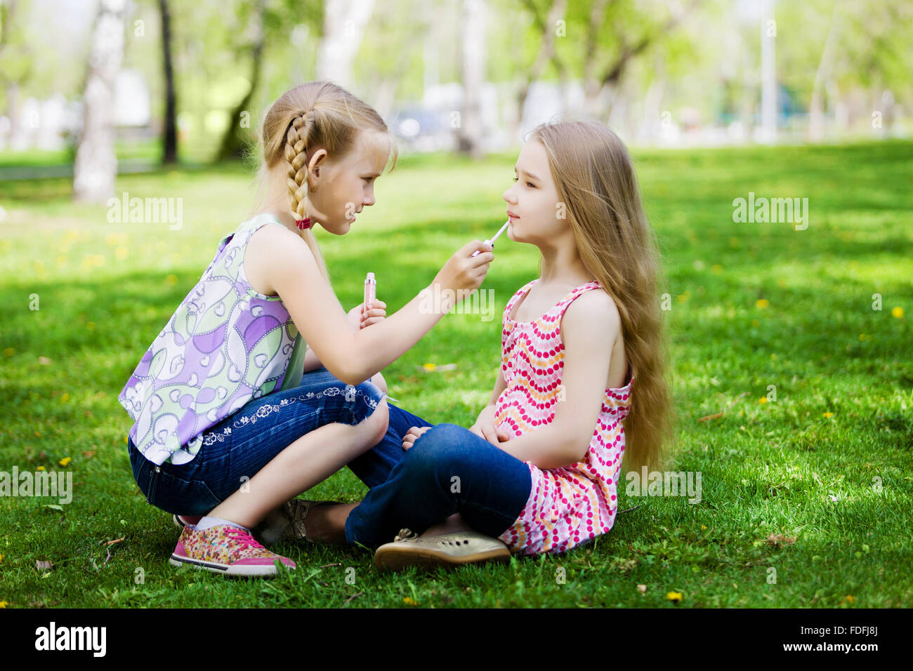 Image of two little cute girl playing on grass in park Stock Photo - Alamy