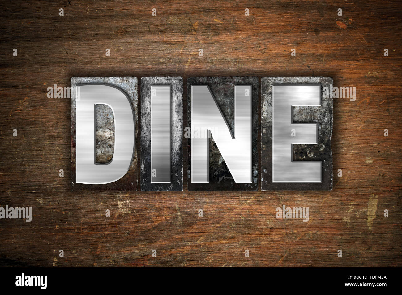 The word "Dine" written in vintage metal letterpress type on an aged ...