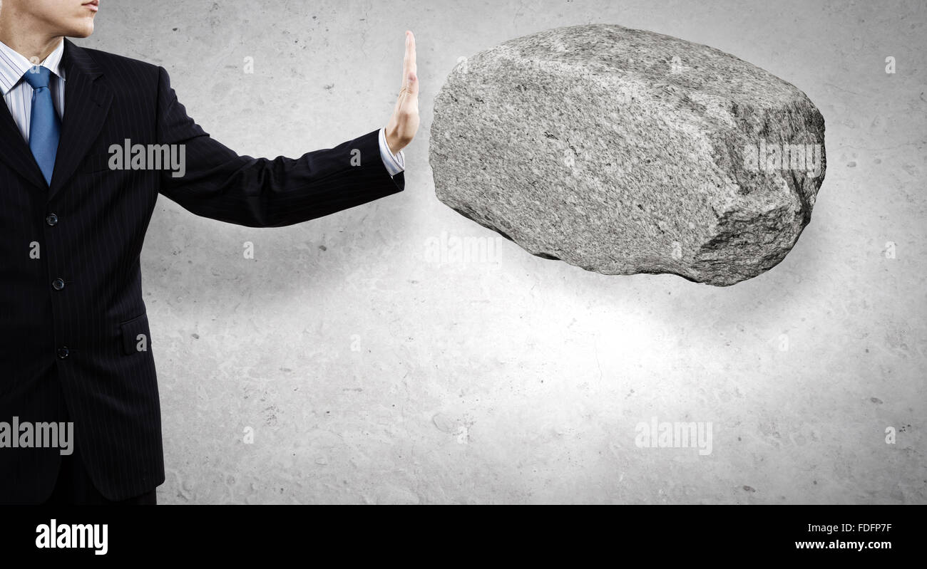 Businessman in suit huge holding stone in palm Stock Photo - Alamy