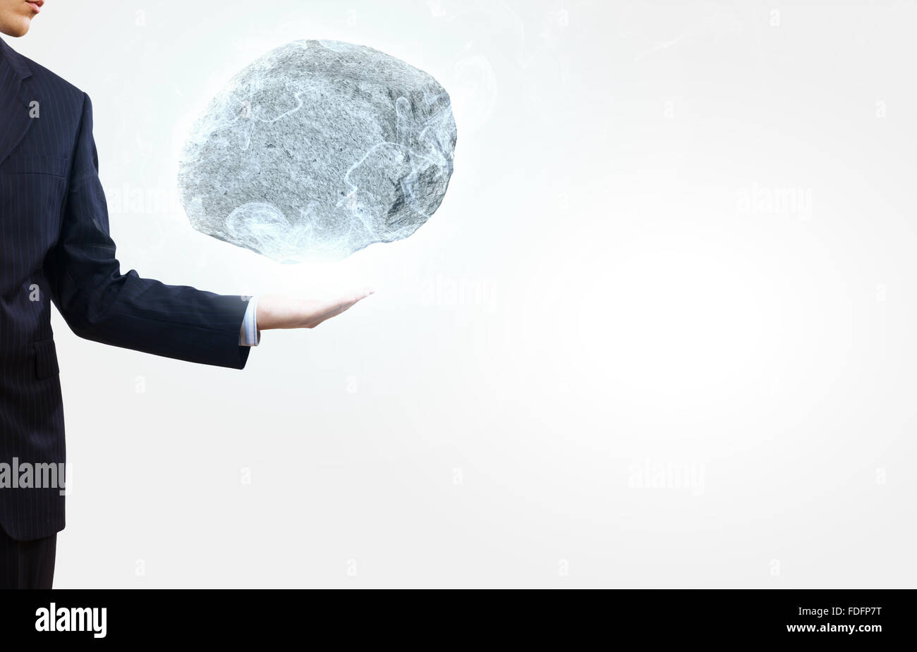 Businessman in suit huge holding stone in palm Stock Photo - Alamy