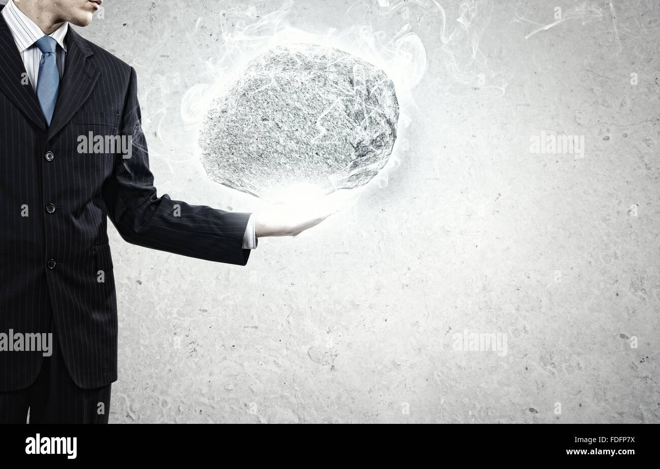 Businessman in suit huge holding stone in palm Stock Photo - Alamy