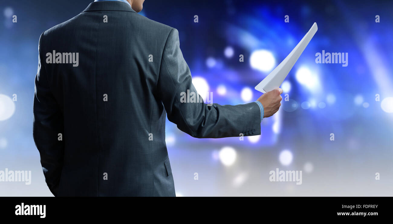 Back view of businessman speaker standing on podium in lights Stock ...