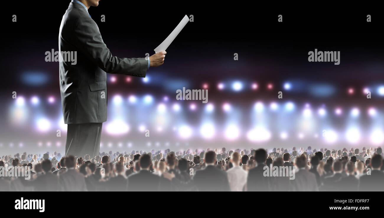 Back view of businessman speaker standing on podium in lights Stock ...