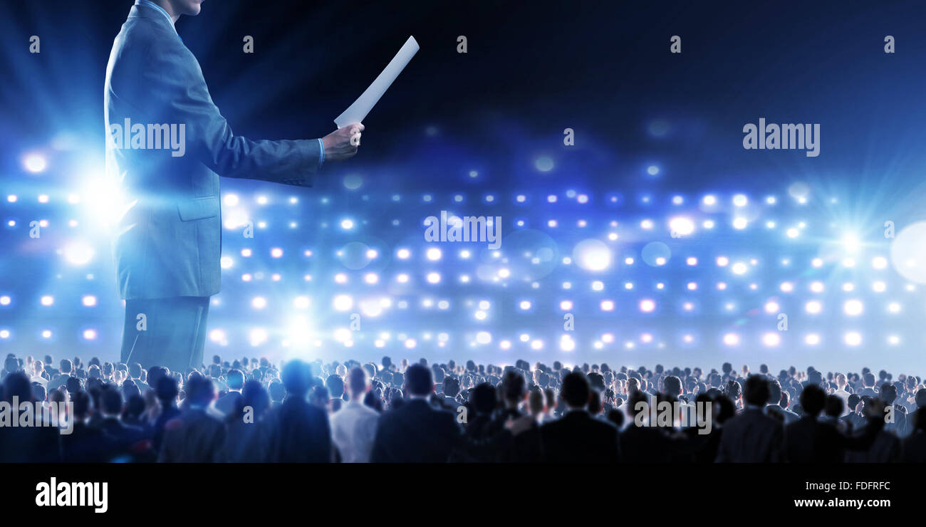 Back view of businessman speaker standing on podium in lights Stock ...