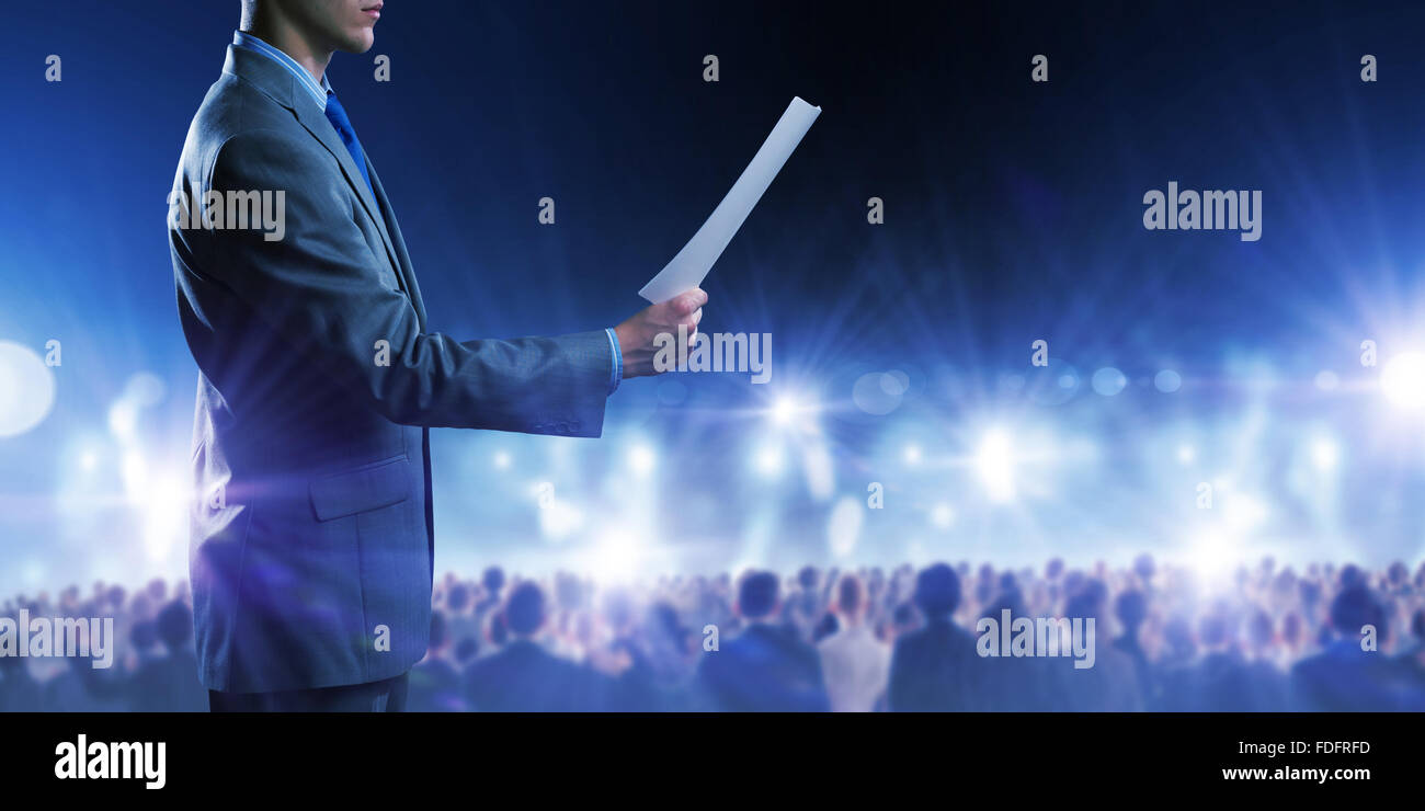 Back view of businessman speaker standing on podium in lights Stock ...