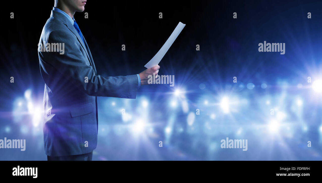 Back view of businessman speaker standing on podium in lights Stock ...
