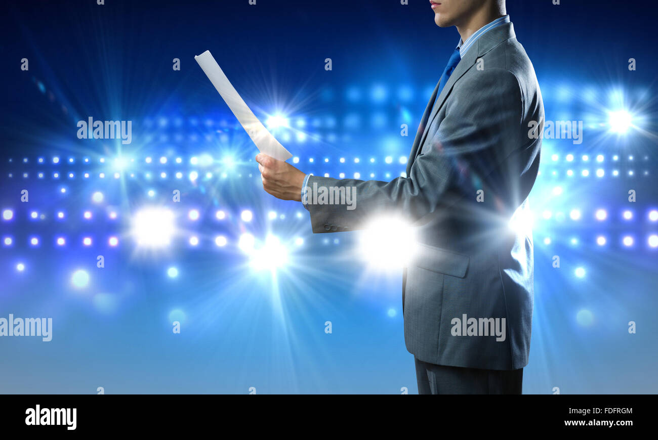 Back view of businessman speaker standing on podium in lights Stock ...