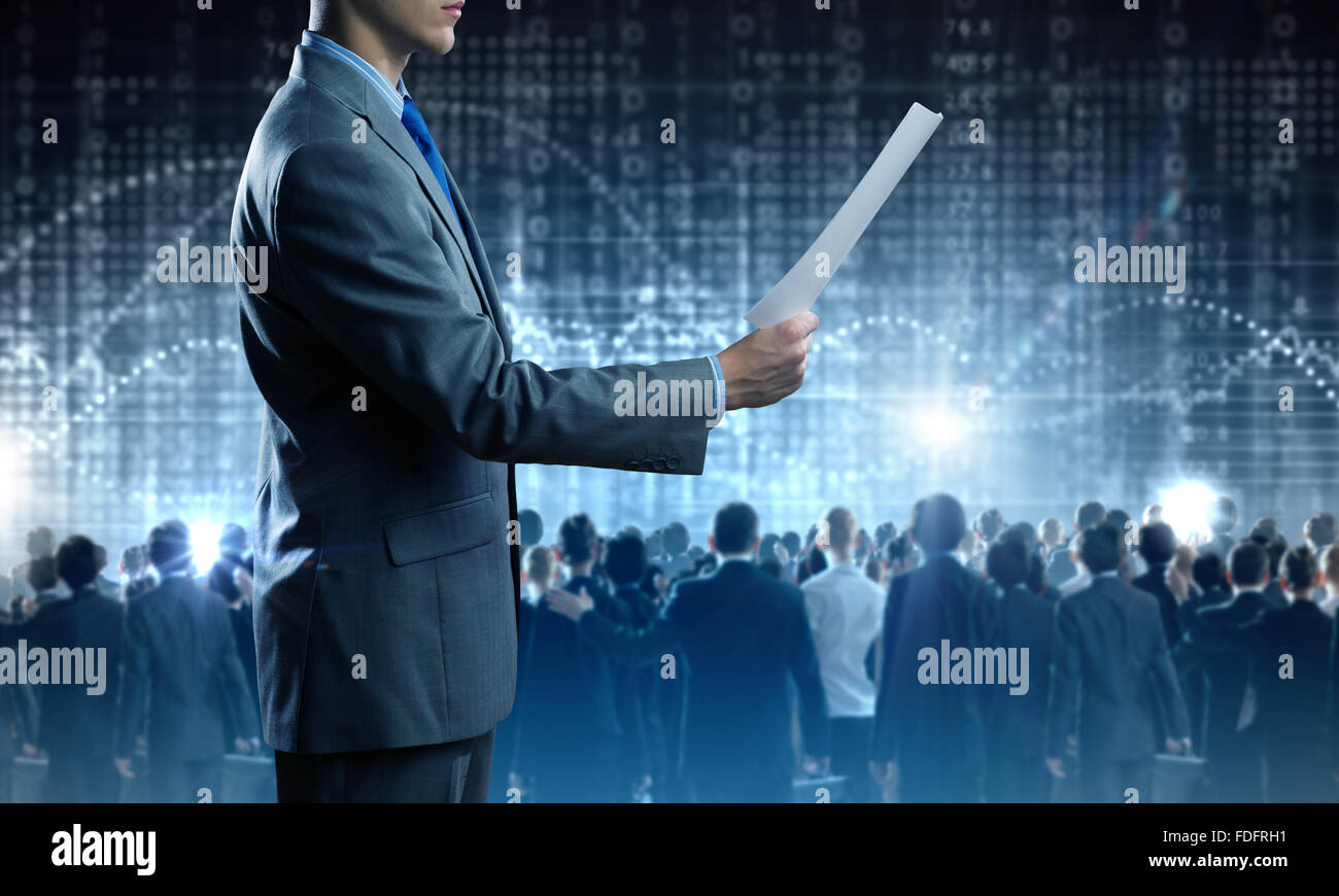 Back view of businessman speaker standing on podium in lights Stock ...