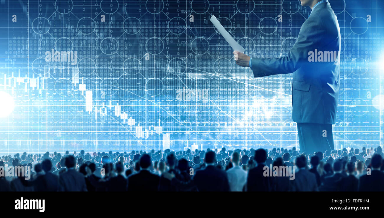 Back view of businessman speaker standing on podium with papers in hand ...
