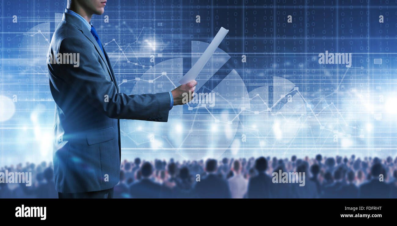 Back view of businessman speaker standing on podium with papers in hand ...
