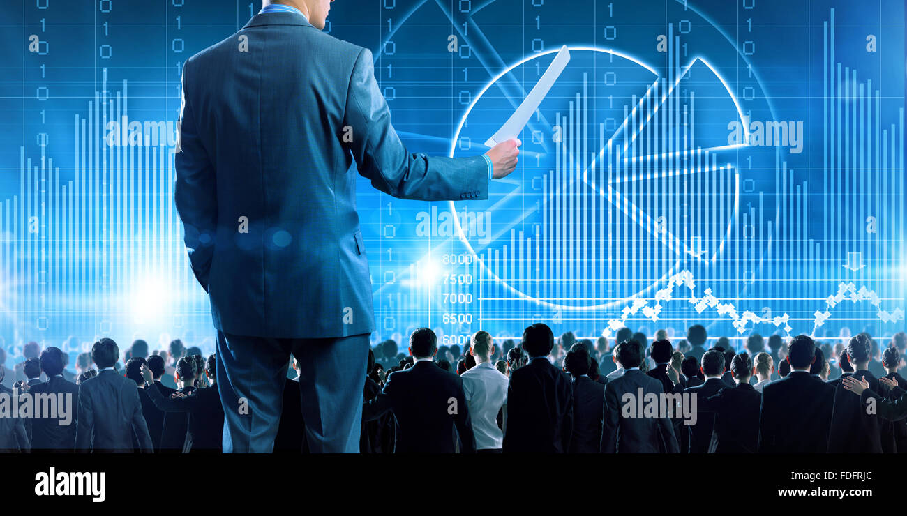 Back view of businessman speaker standing on podium with papers in hand ...