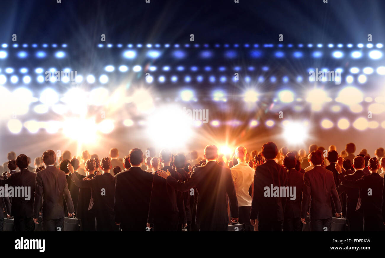 Crowd of businesspeople standing with back with lights at background ...