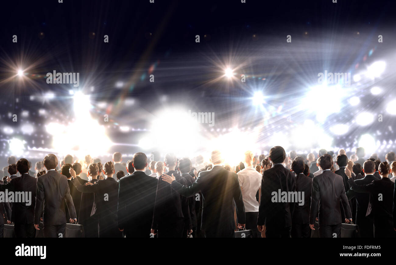 Crowd of businesspeople standing with back with lights at background ...