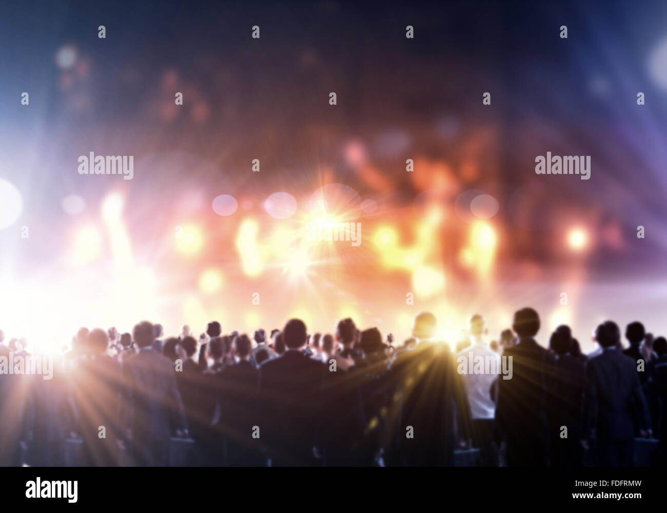 Crowd of businesspeople standing with back with lights at background ...
