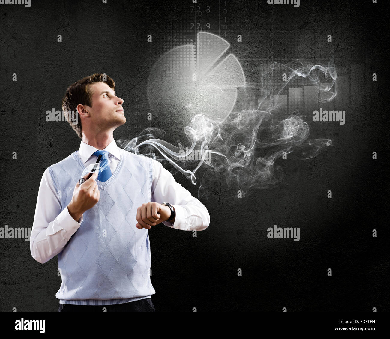 Young businessman smoking pipe with diagrams and graphs at background ...