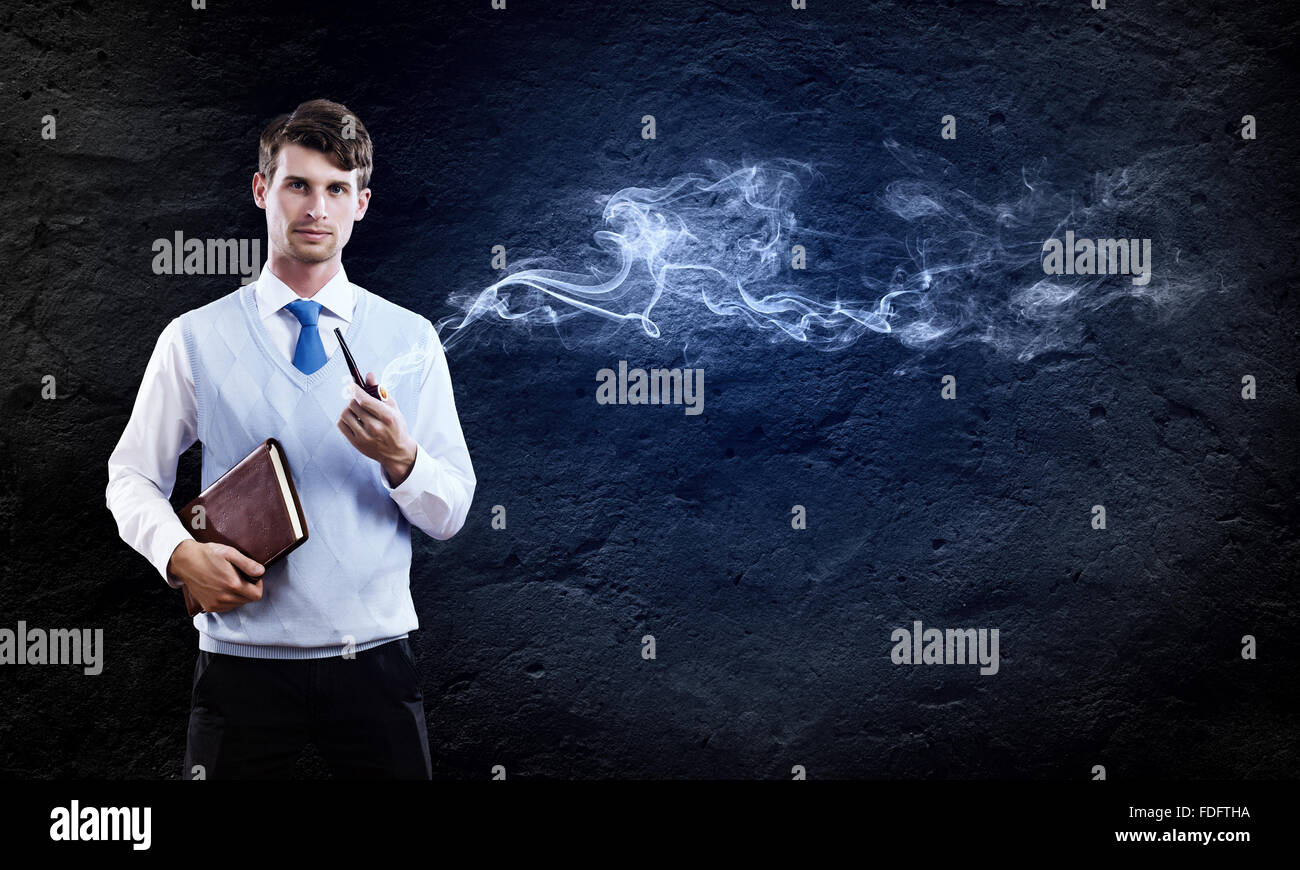 Young handsome businessman smoking pipe against black background Stock ...