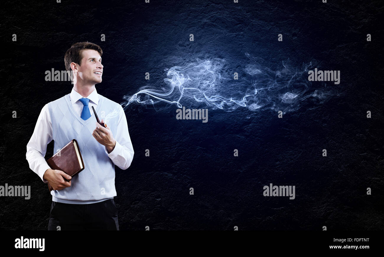 Young handsome businessman smoking pipe against black background Stock ...