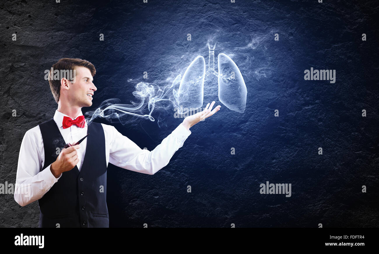 Conceptual image of young handsome man smoking pipe Stock Photo - Alamy
