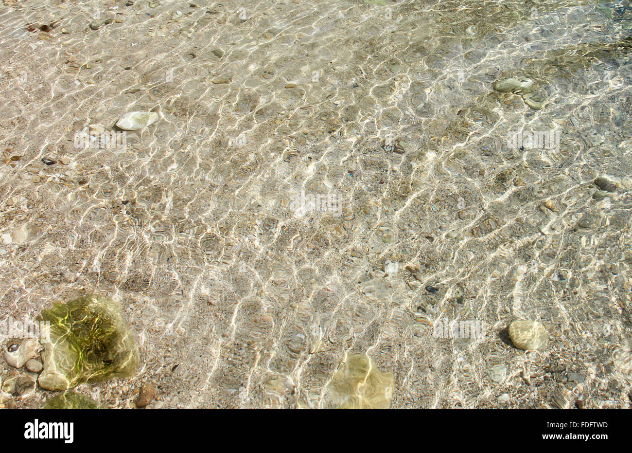 Ripples of a beautiful clean sea showing sand pebbles and stones Stock ...