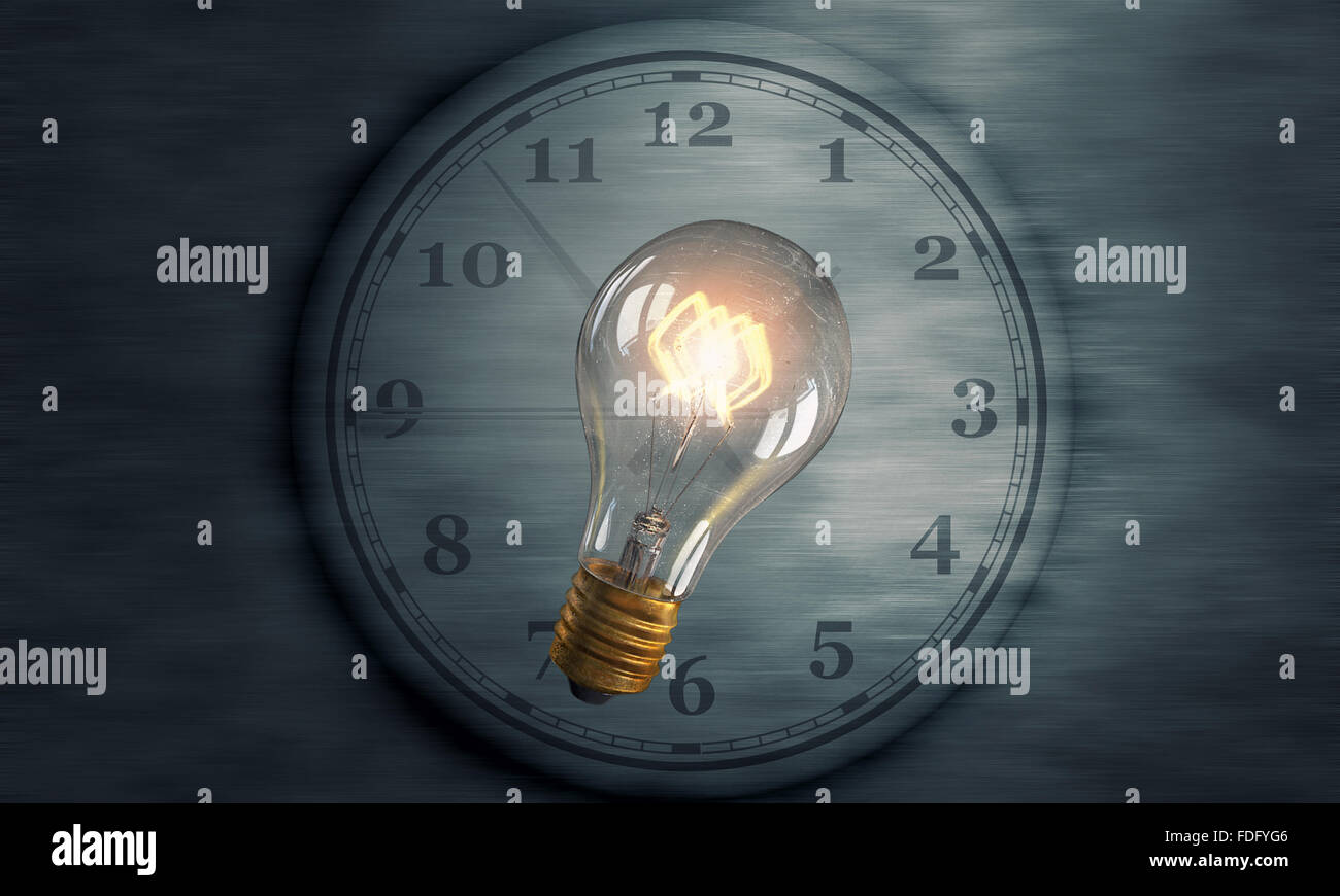 Conceptual image with light bulb and clock on dark background Stock ...