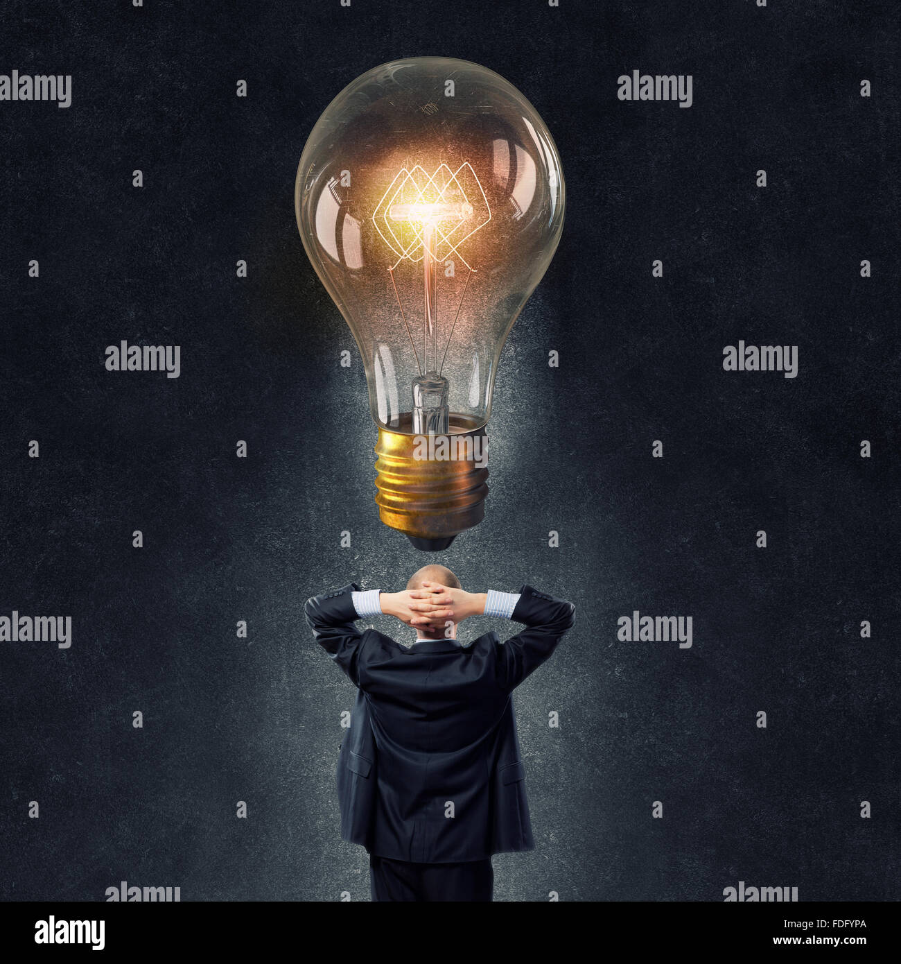 Back view of businessman looking at big light bulb Stock Photo - Alamy