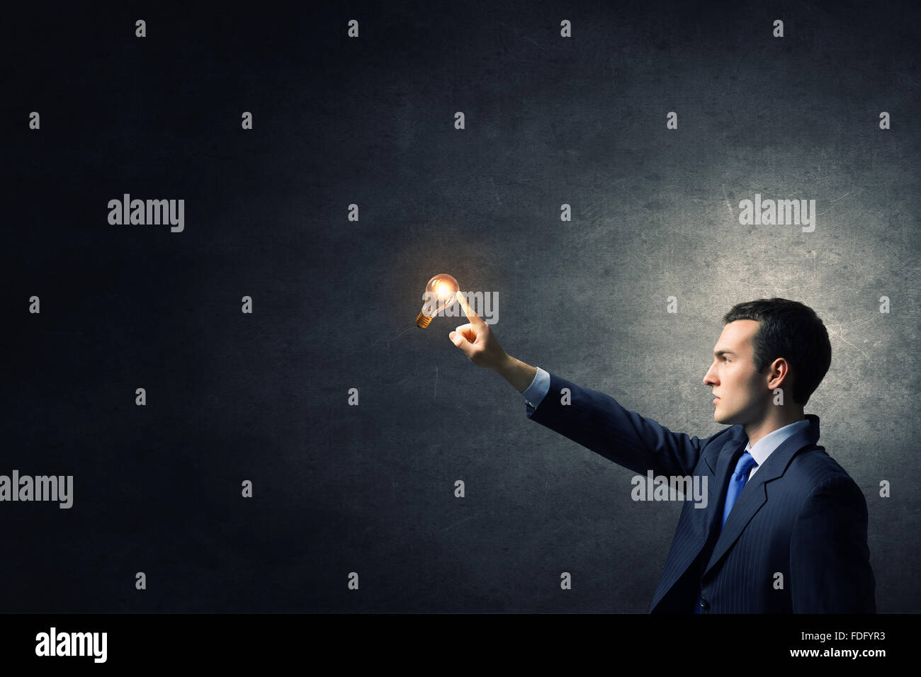 Businessman reaching hand to touch glass light bulb Stock Photo - Alamy