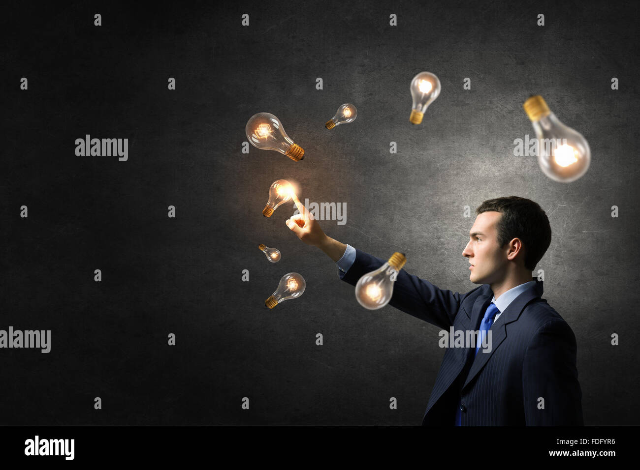 Businessman reaching hand to touch glass light bulb Stock Photo - Alamy