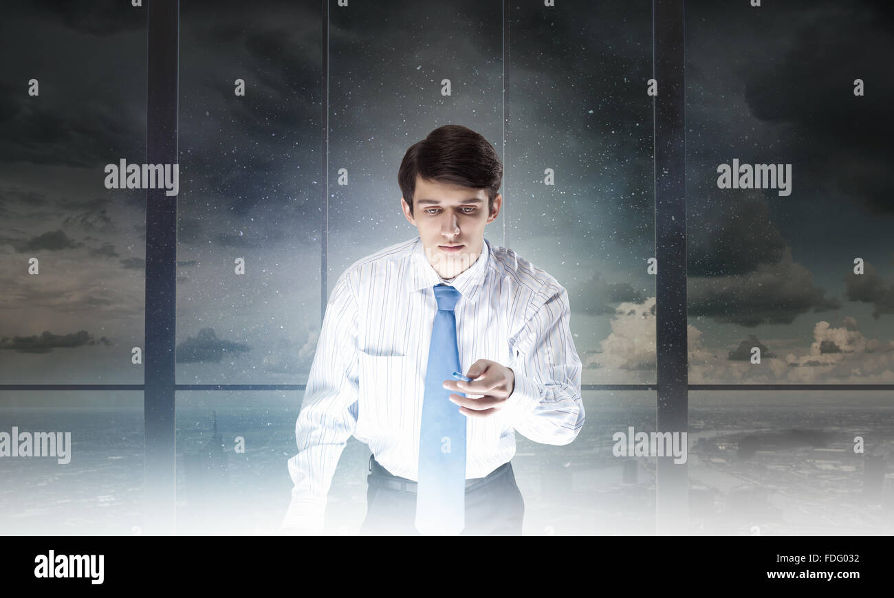 Young businessman examining glass glowing light bulb Stock Photo - Alamy