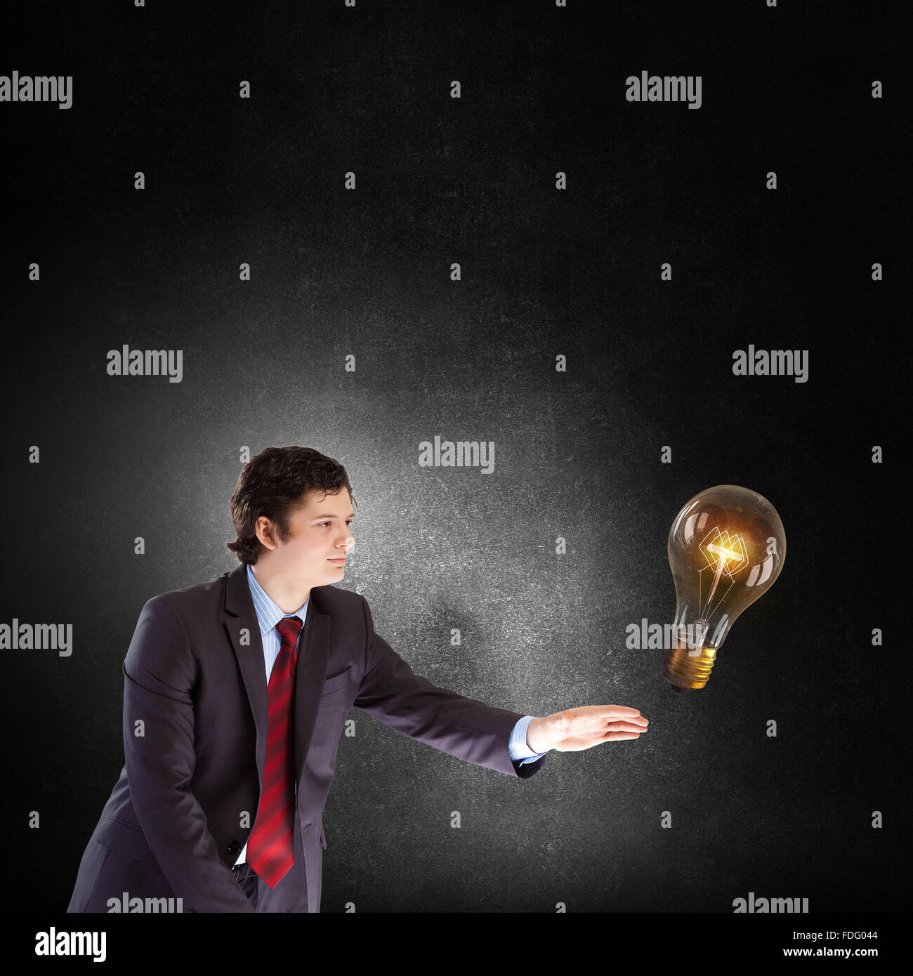 Businessman reaching hand to touch glass light bulb Stock Photo - Alamy
