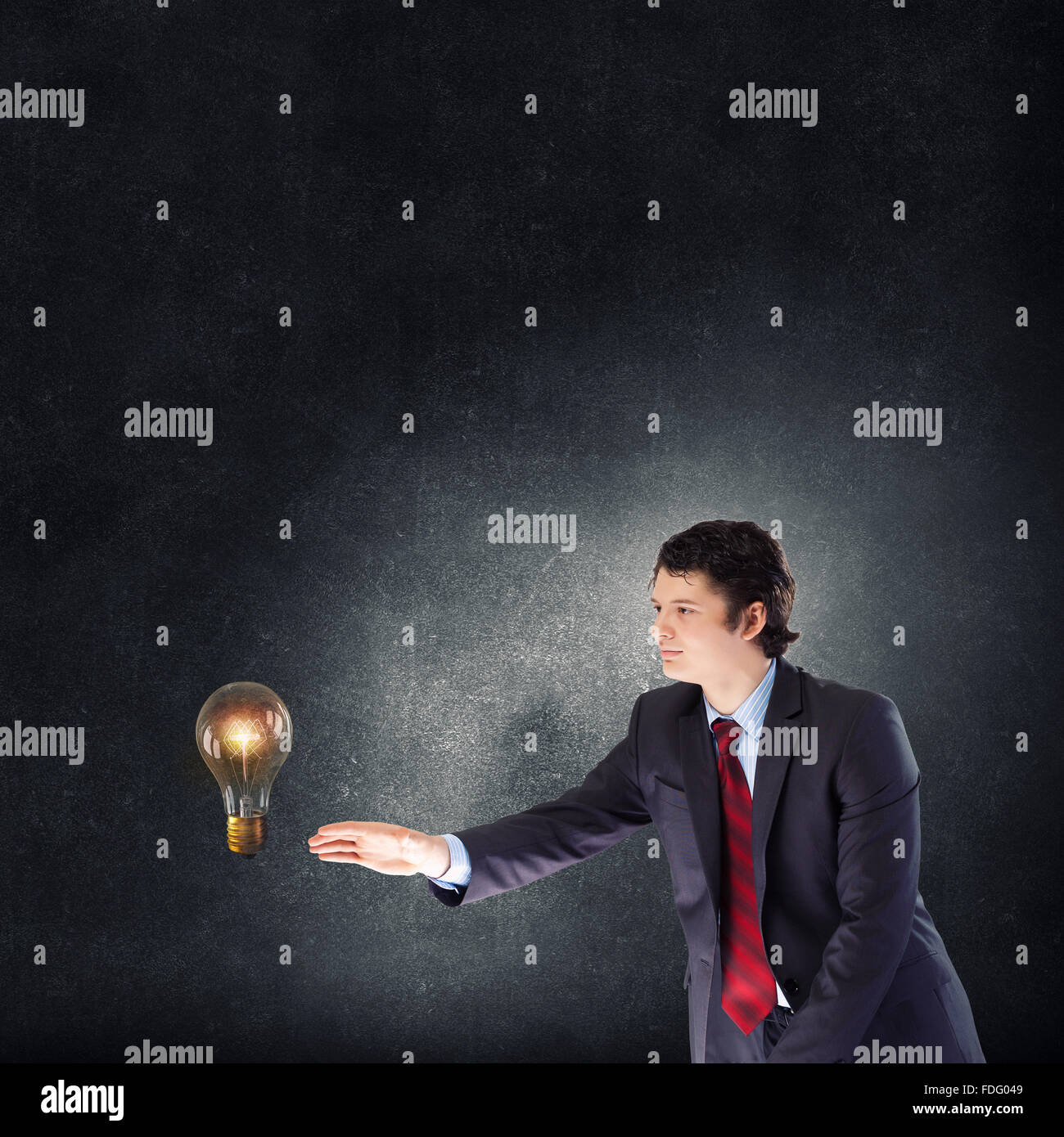 Businessman reaching hand to touch glass light bulb Stock Photo - Alamy