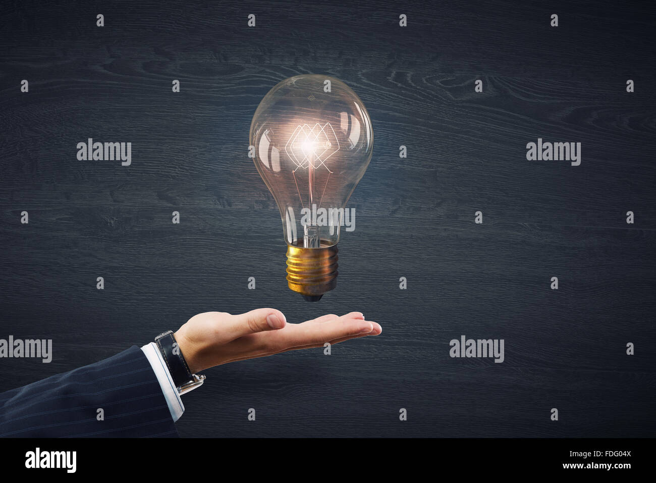 Businessman presenting glass glowing light bulb in his hand Stock Photo ...