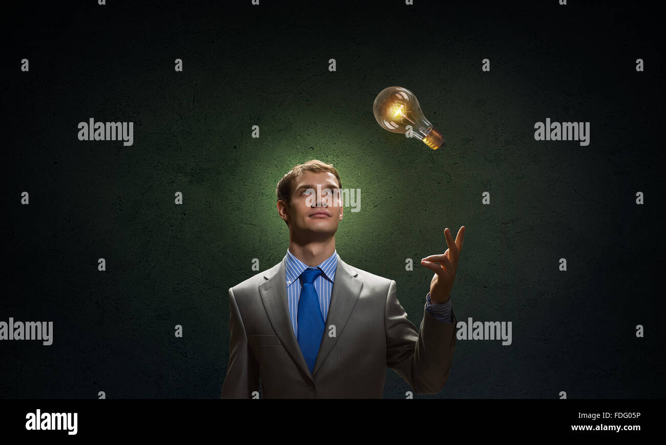 Young businessman pointing with finger at glowing light bulb Stock ...